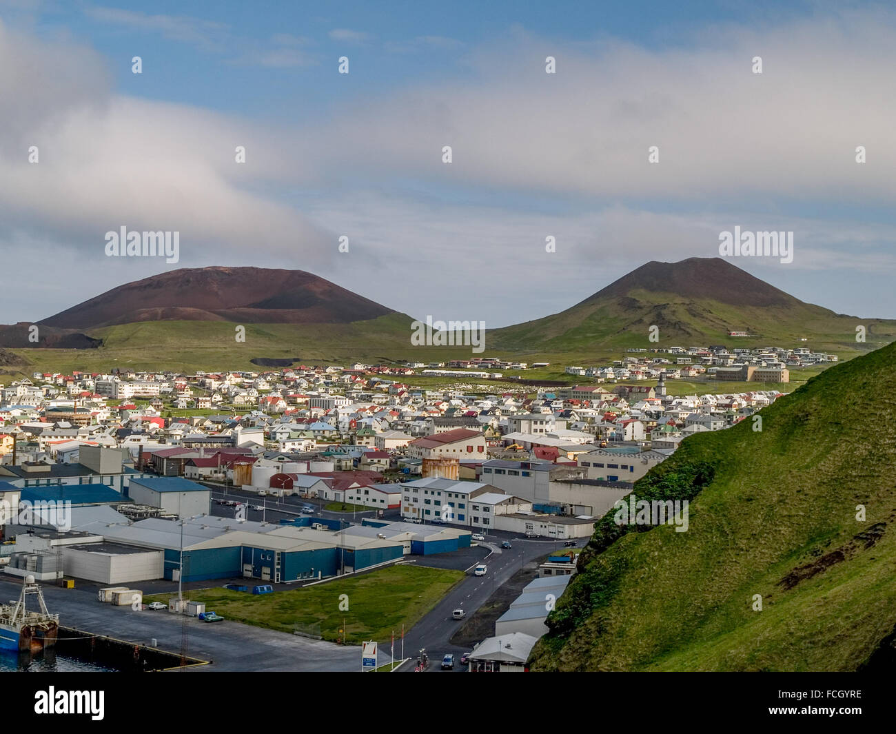 Eldfell and Helgafell volcanoes in front of cityscape in Heimaey ...