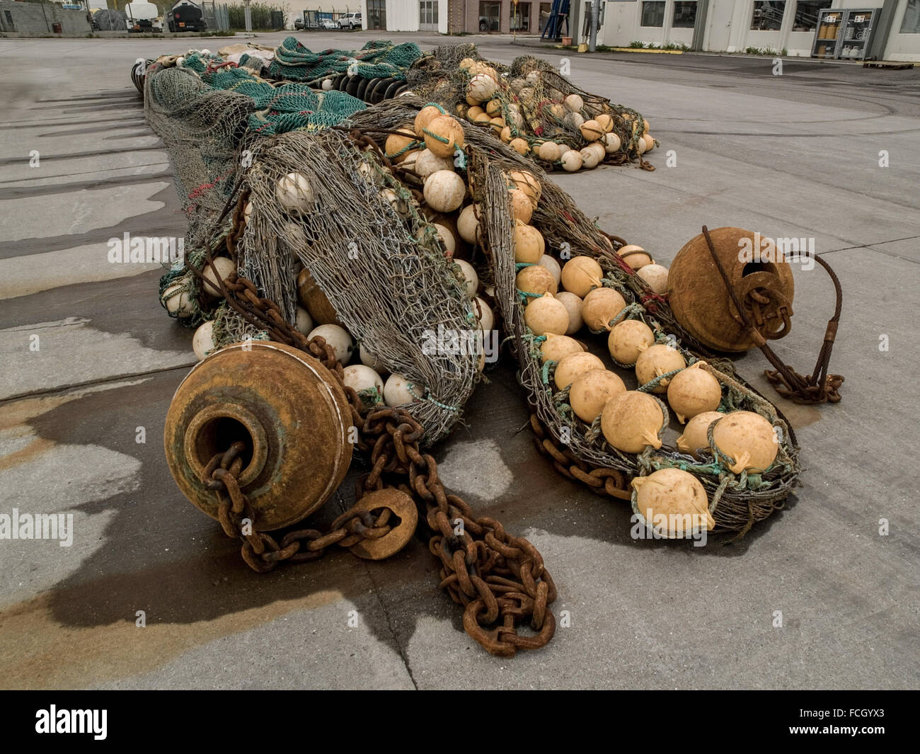 Large rusty industrial fishnet ball and chains in harbour in Isafjordur ...