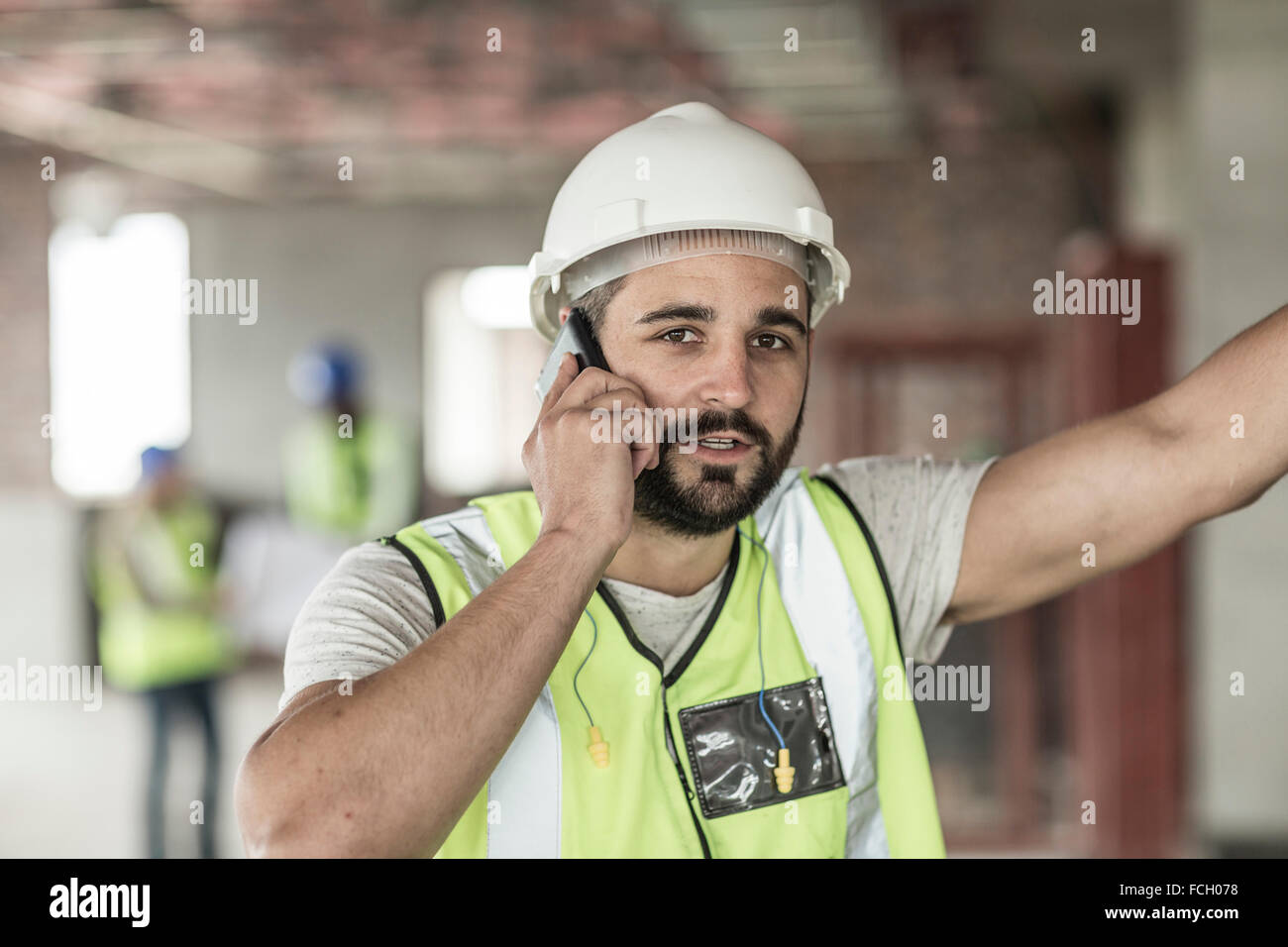 Construction worker on cell phone in construction site Stock Photo - Alamy