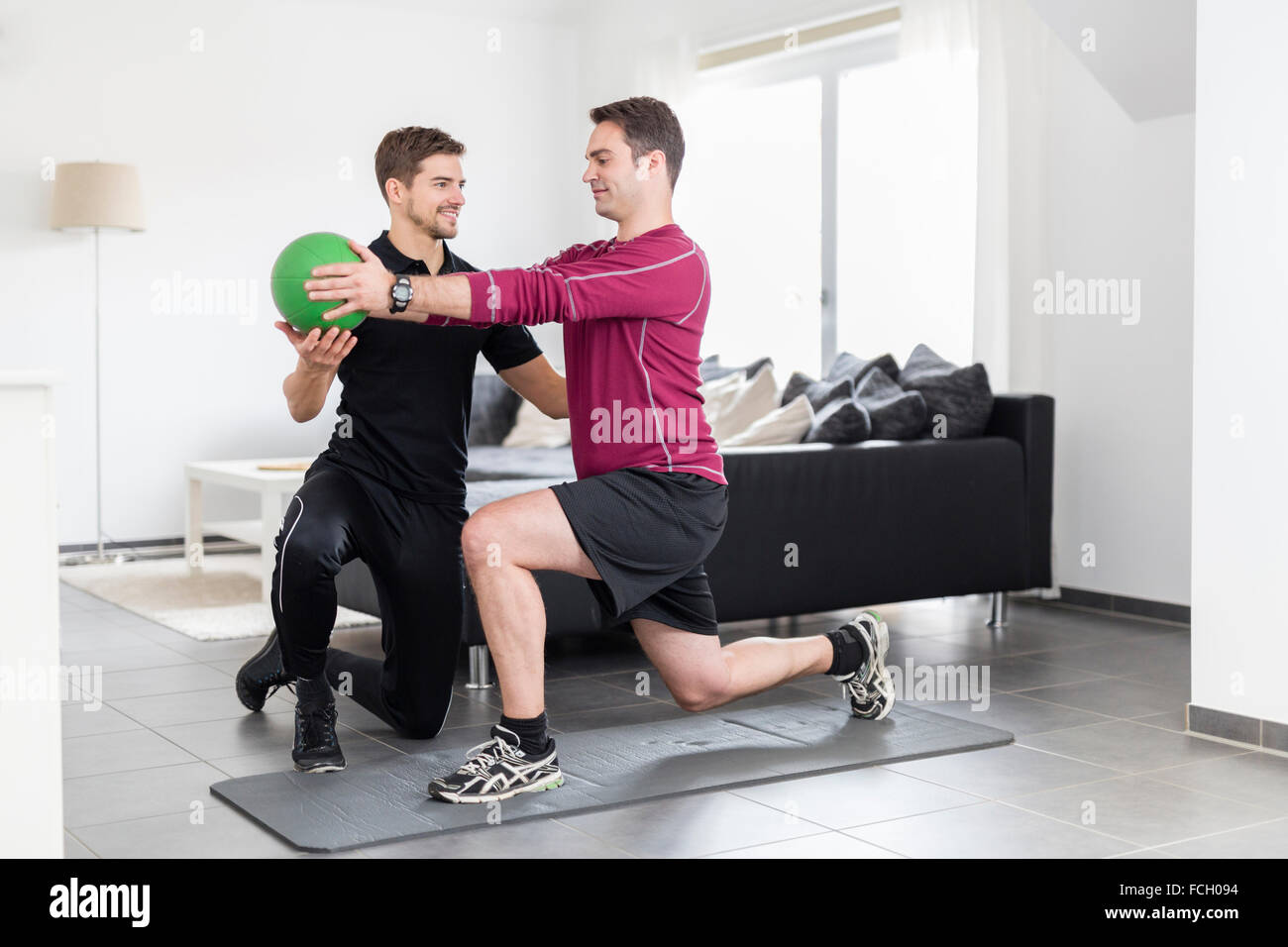 Coach doing exercises man at home Stock Photo - Alamy