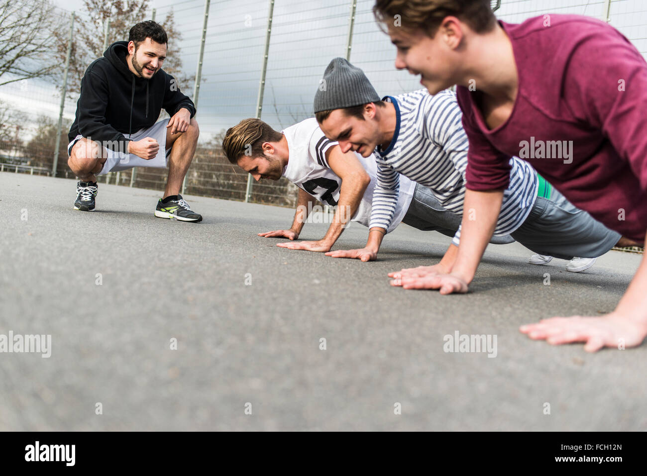 Young man motivating his friends pushups Stock Photo - Alamy