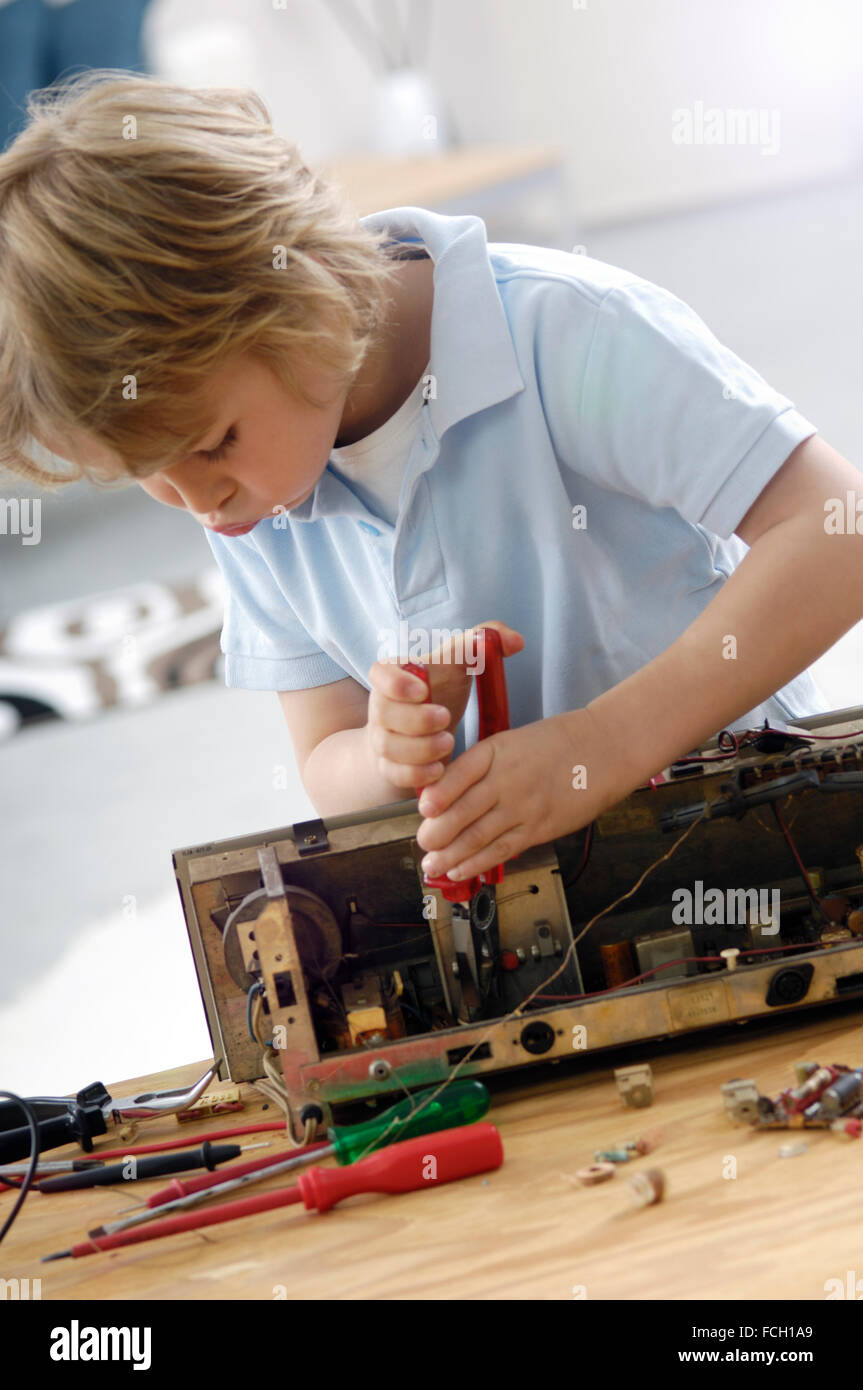 Little boy disassembling an old radio Stock Photo - Alamy