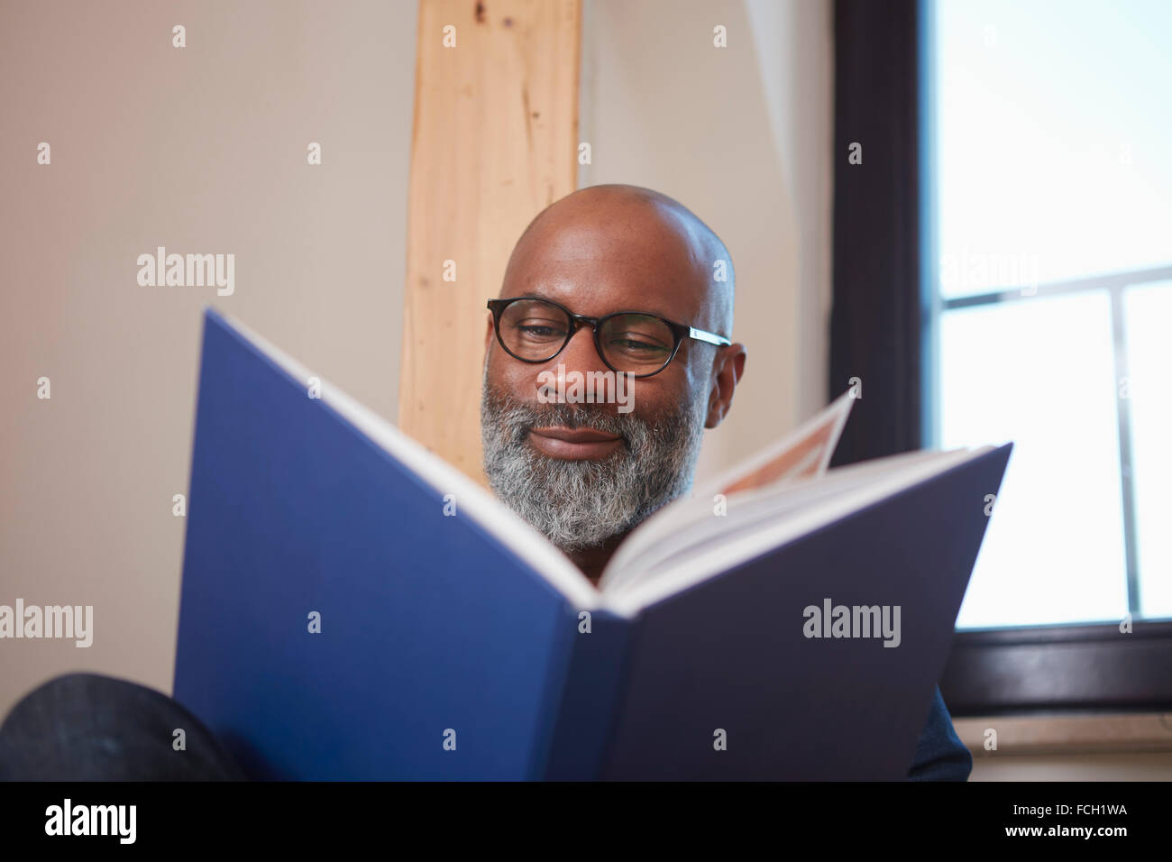 Portrait of man reading a book Stock Photo - Alamy