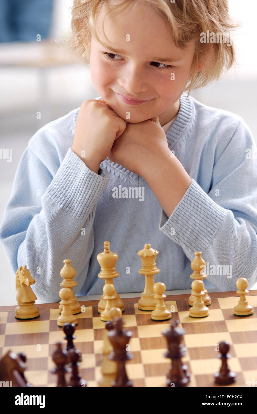 Portrait of smiling little boy playing chess Stock Photo - Alamy