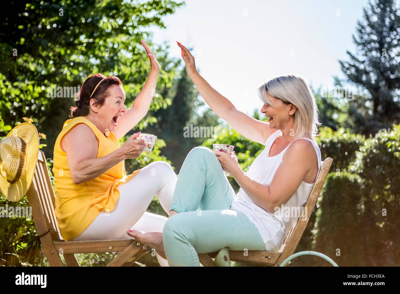 Cheerful female friends high fiving hi-res stock photography and images ...