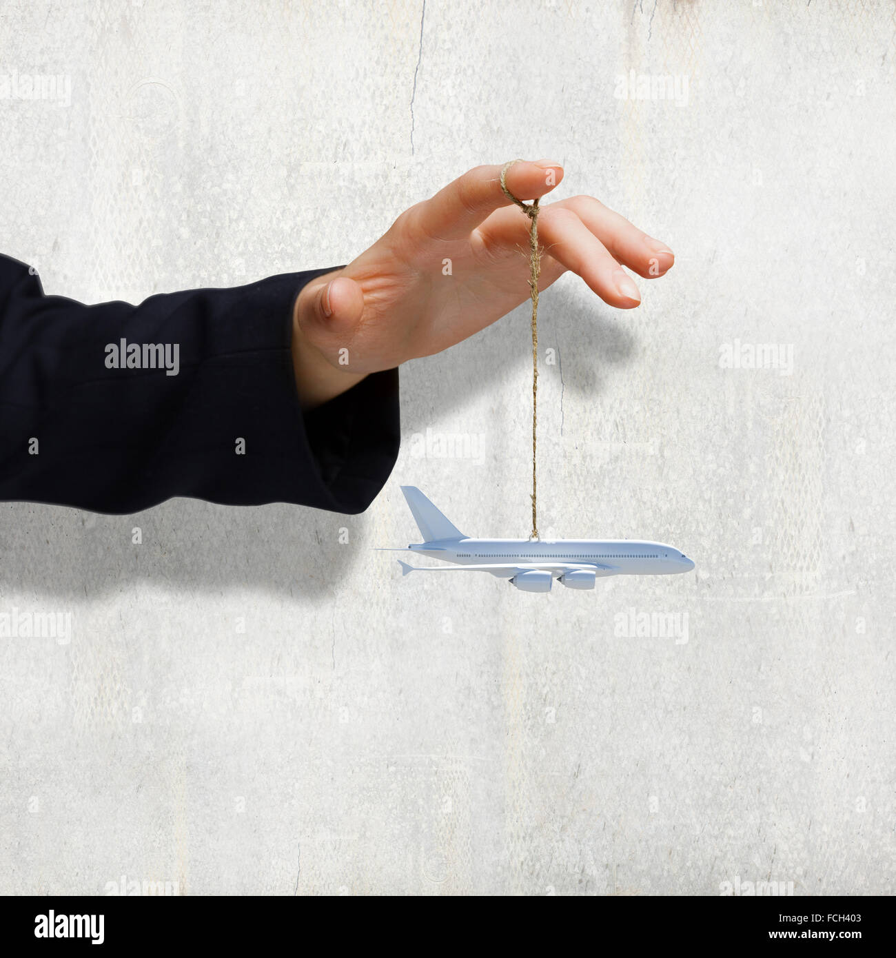 Close up of businessman hand holding airplane model on rope Stock Photo ...