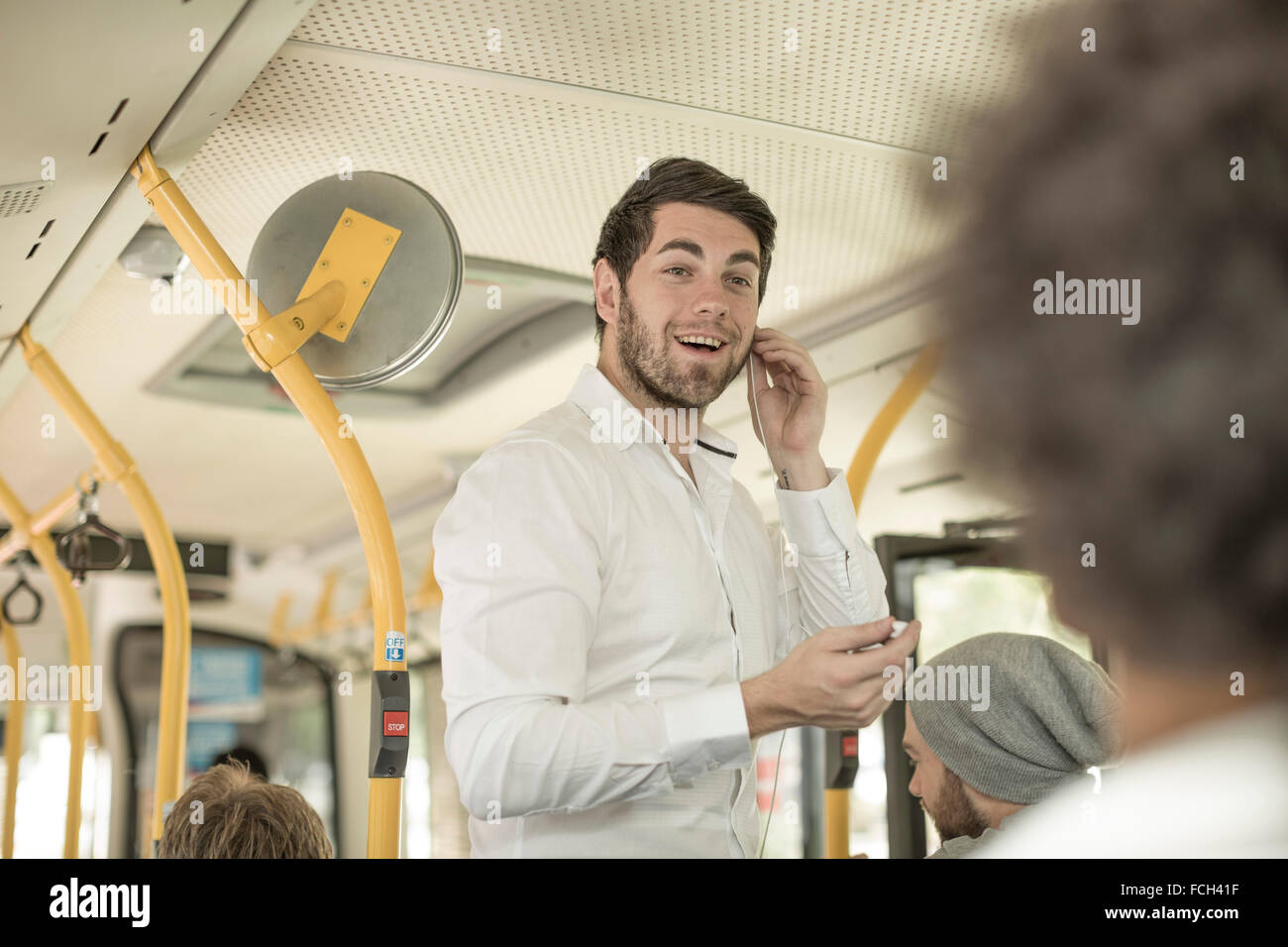 Young man talking on the phone in a city bus Stock Photo - Alamy