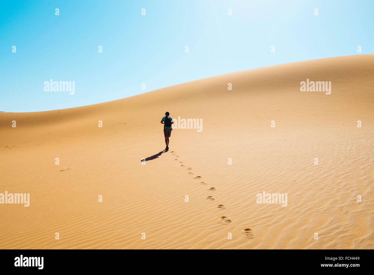 Namibia Namib Desert Sossusvlei Man walking through the dunes Stock ...