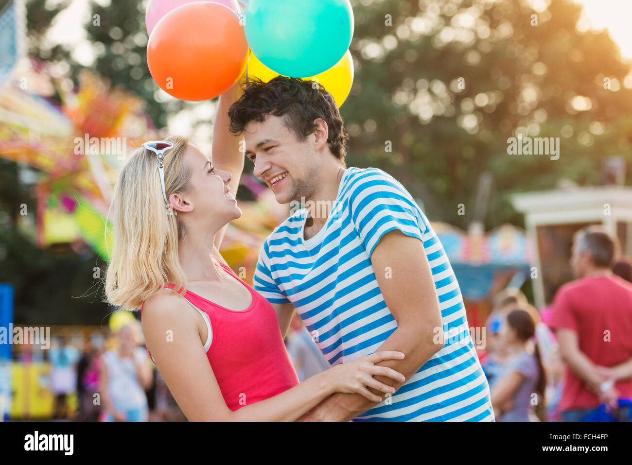 Happy couple at fun fair Stock Photo - Alamy