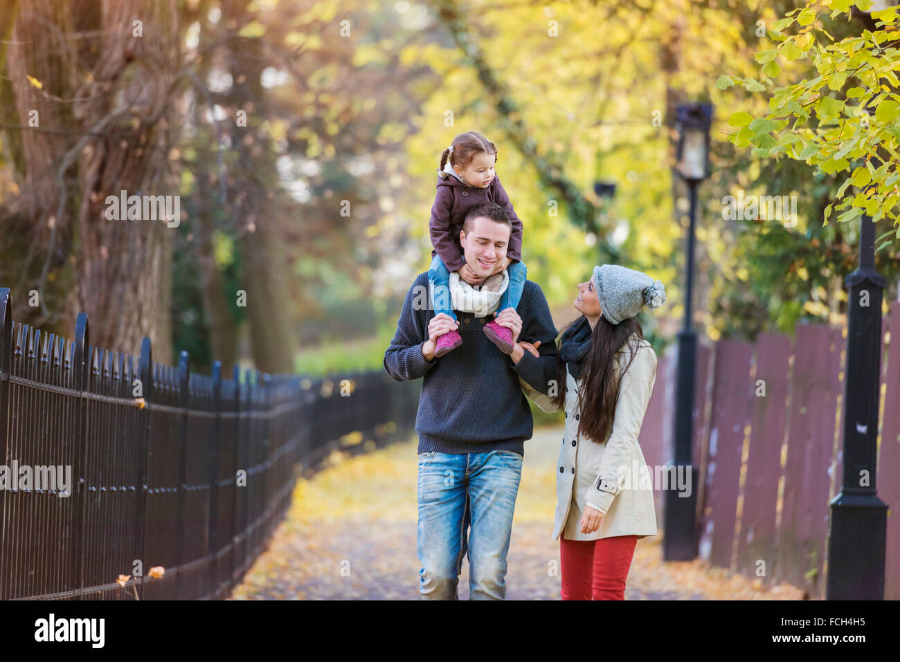 Family going for a walk in autumnal park Stock Photo - Alamy