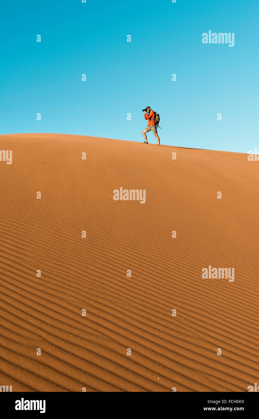 Namibia Namib Desert Sossusvlei Man taking pictures on a dune Stock ...