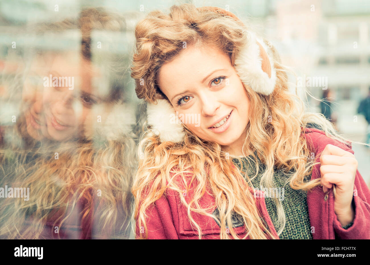 Portrait of smiling blond woman ear muff Stock Photo - Alamy