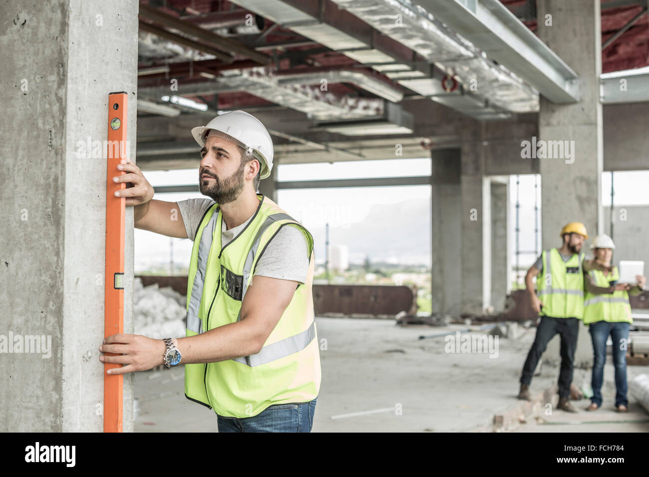 Construction worker using water level in construction site Stock Photo ...