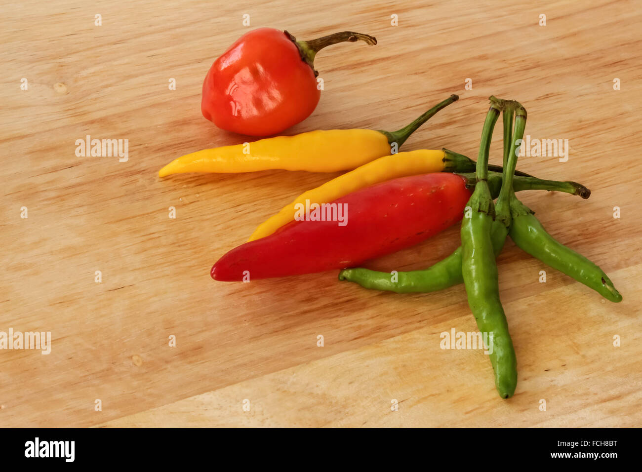 Colorful chili - red, green, yellow - wood background Stock Photo - Alamy