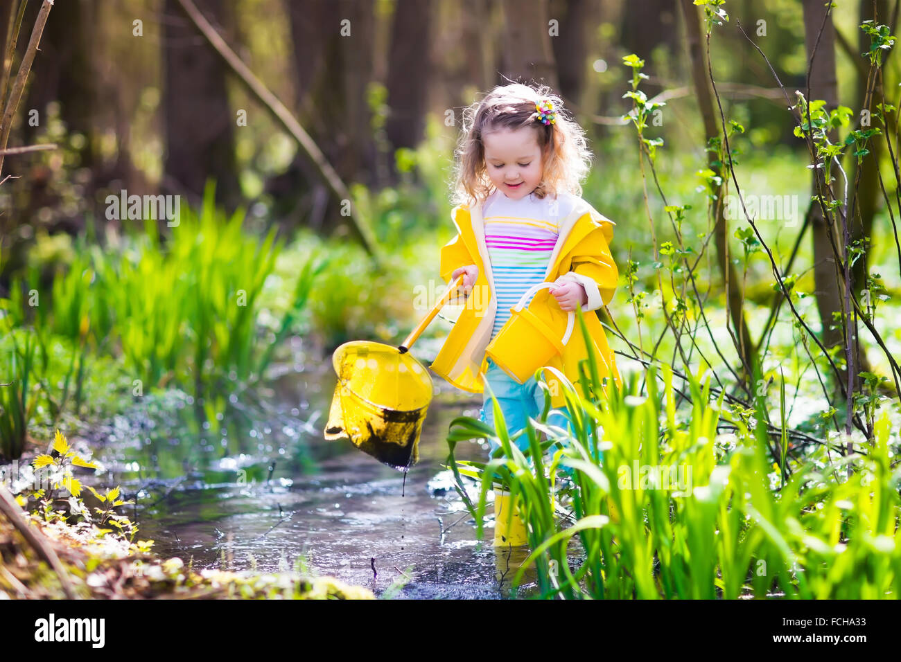 Children playing outdoors. Preschool kids catching frog with net. Boy ...