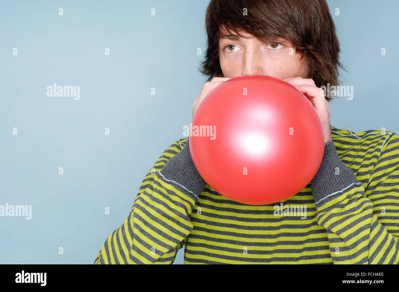 Boy blowing up red balloon hi-res stock photography and images - Alamy