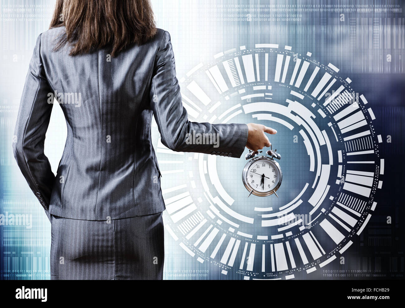 Rear view of businesswoman holding old alarm clock Stock Photo - Alamy