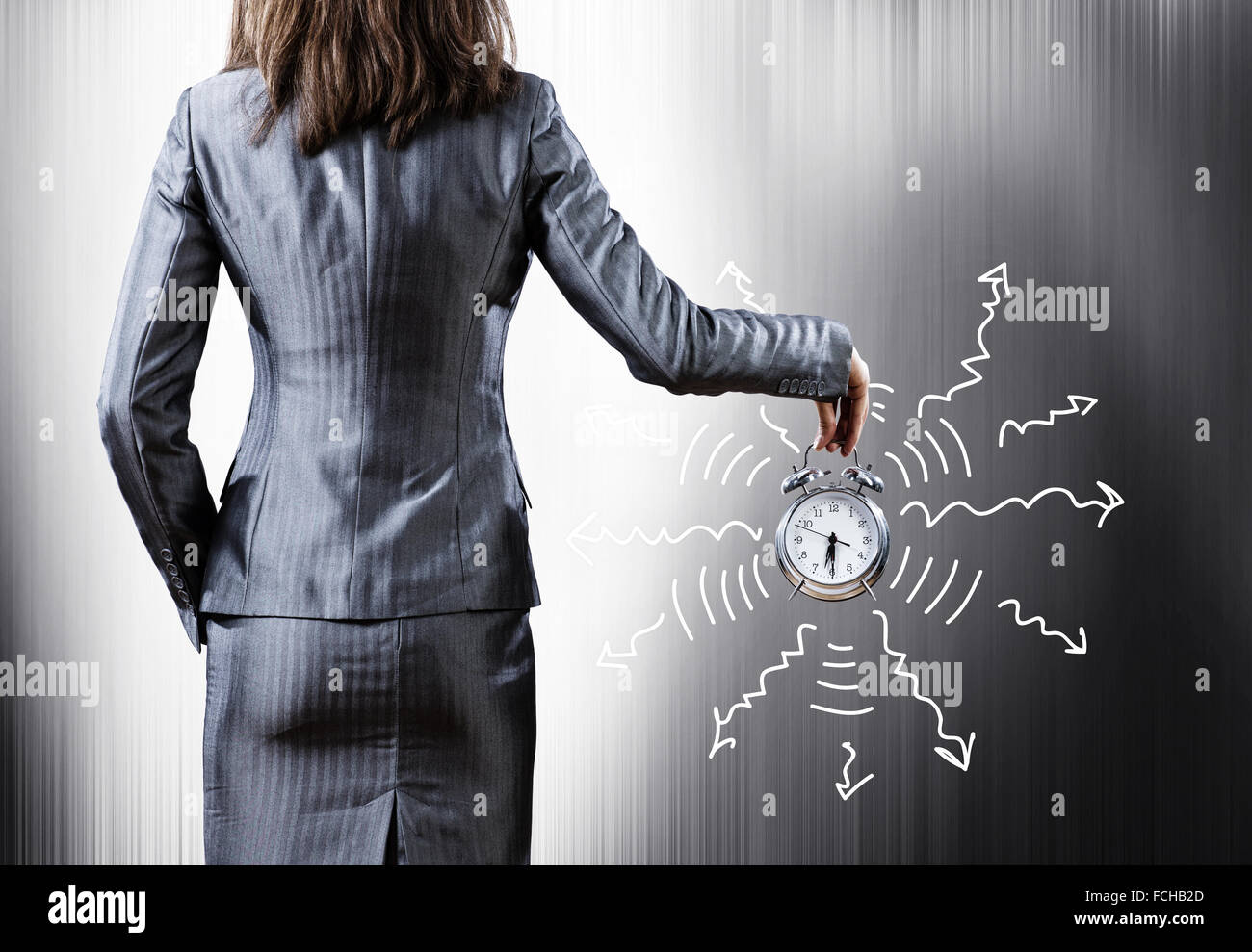Rear view of businesswoman holding old alarm clock Stock Photo - Alamy