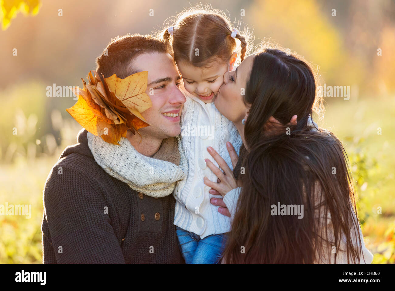 Happy family hugging in autumnal park Stock Photo - Alamy