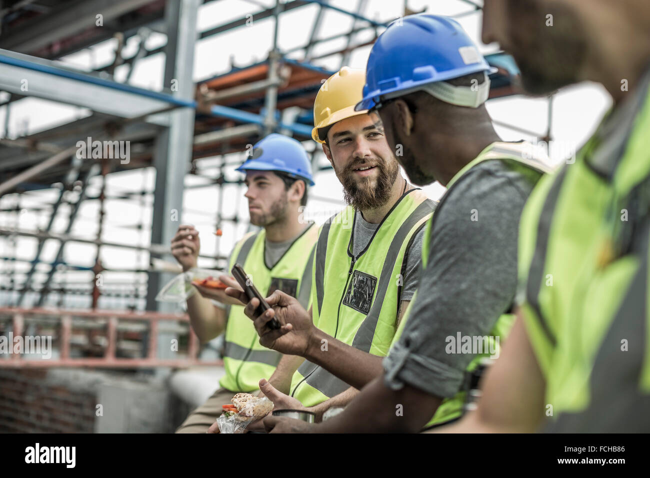 Construction workers having a break on construction site Stock Photo ...