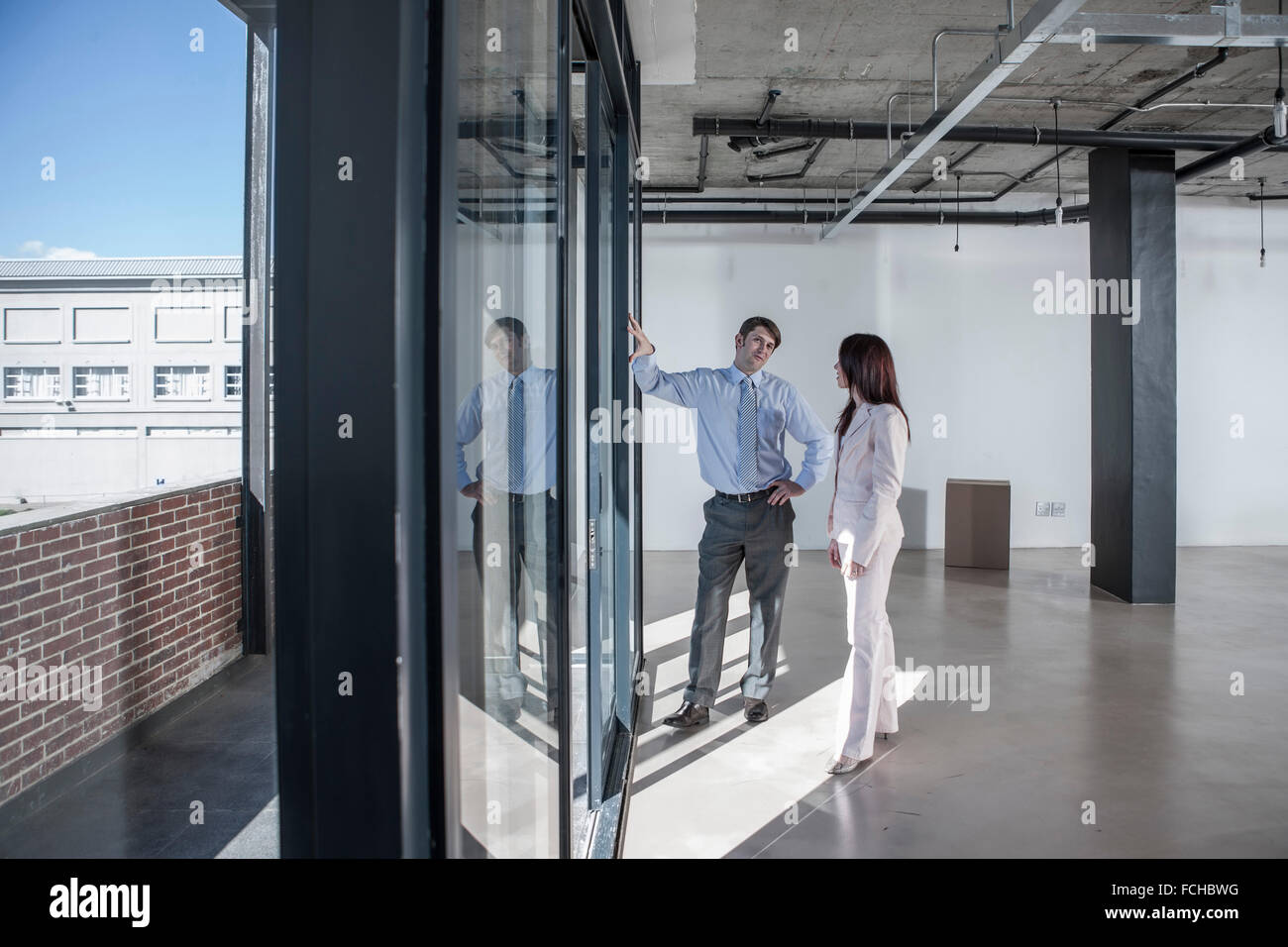 Businesspeople standing at the window in new open office Stock Photo ...