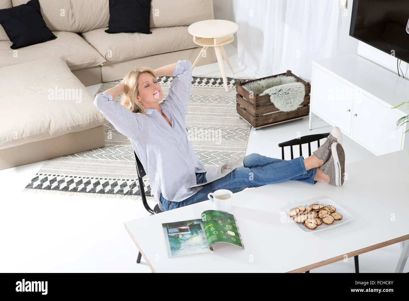 Woman relaxing feet up on the table in her living room Stock Photo - Alamy