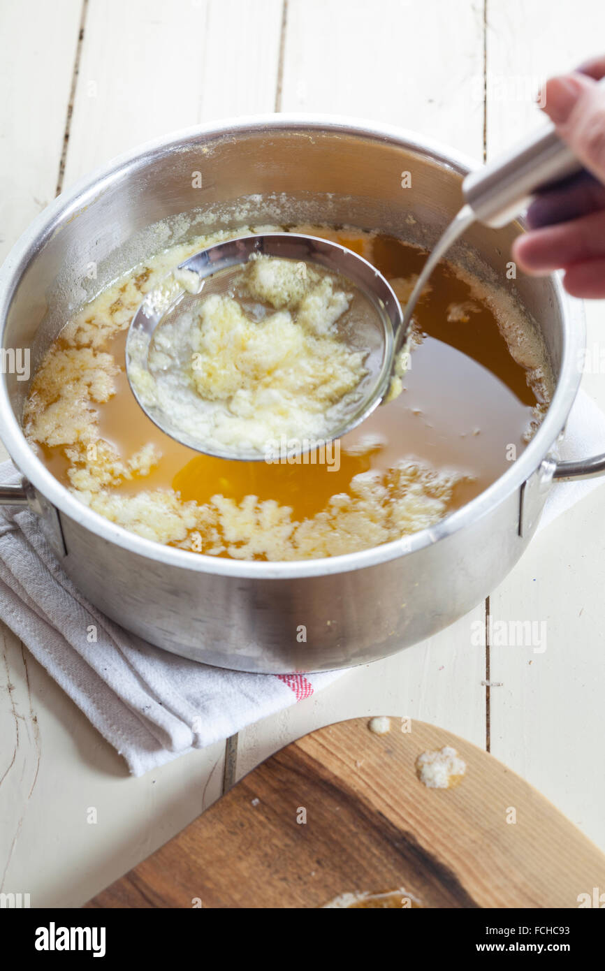 Scooping froth from melted butter Stock Photo - Alamy