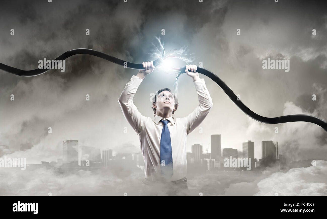 Determined businessman tearing electricity cable with hands Stock Photo ...