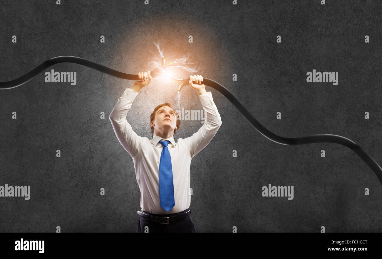 Determined businessman tearing electricity cable with hands Stock Photo ...