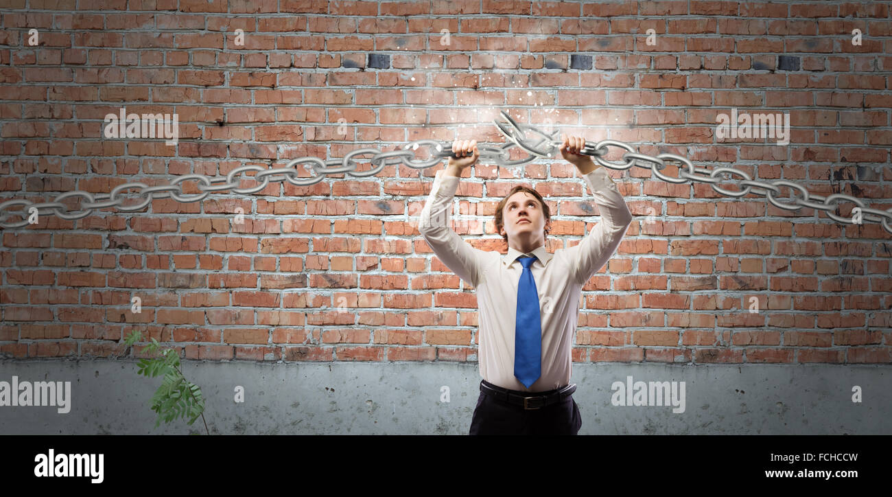 Young strong businessman tearing metal chain with hands Stock Photo - Alamy