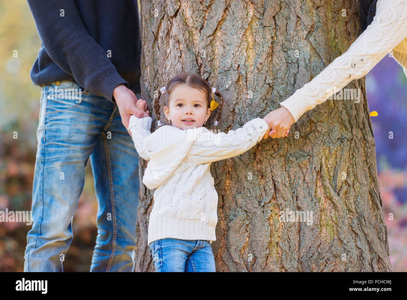Family of three hugging tree Stock Photo - Alamy