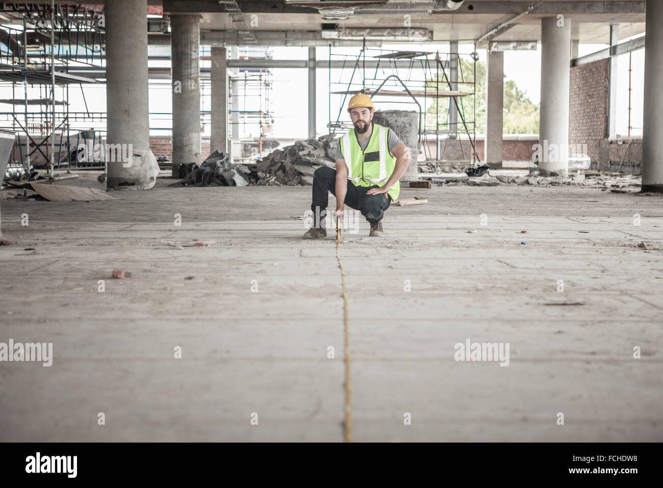 Construction worker using tape measure in construction site Stock Photo ...