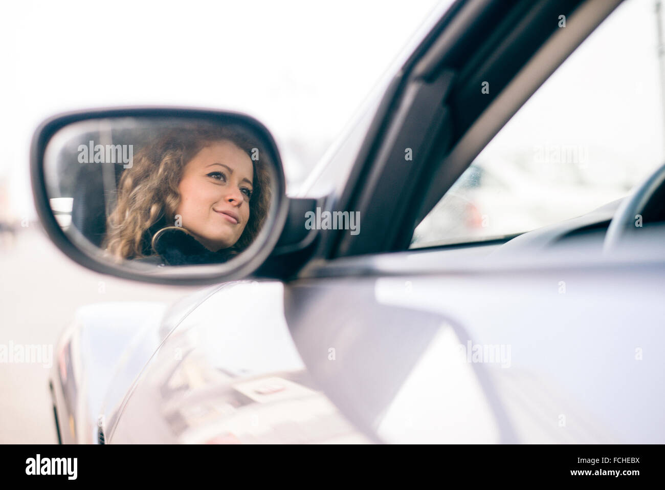 Woman driving car mirrored in wing mirror Stock Photo - Alamy