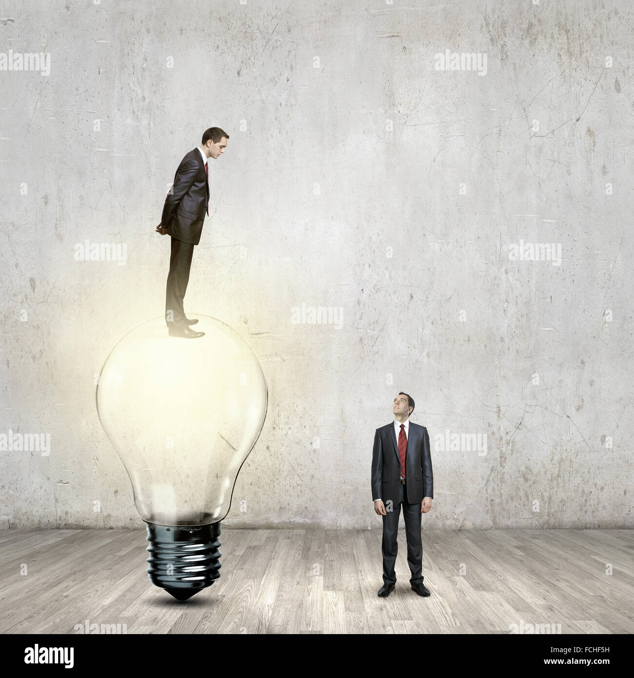 Businessman standing on top of light bulb and looking down Stock Photo ...