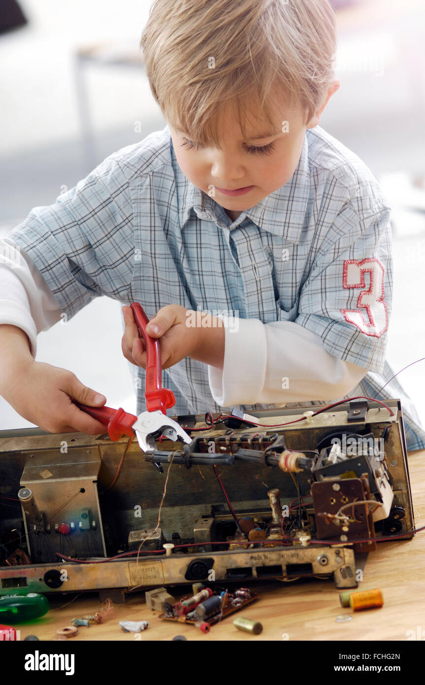 Little boy disassembling an old radio Stock Photo - Alamy