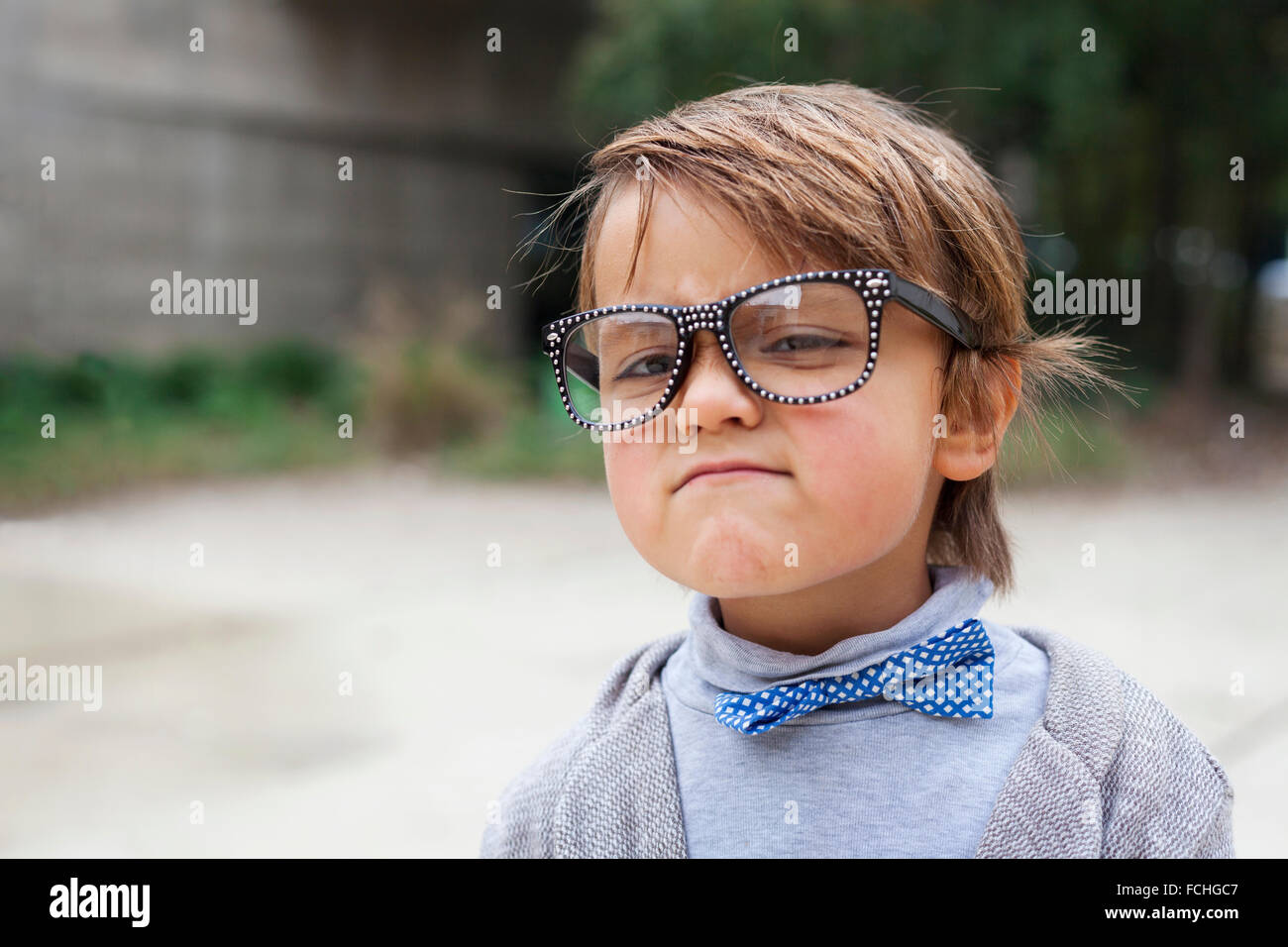 Portrait of little boy wearing oversized spectacles and boy tie making ...