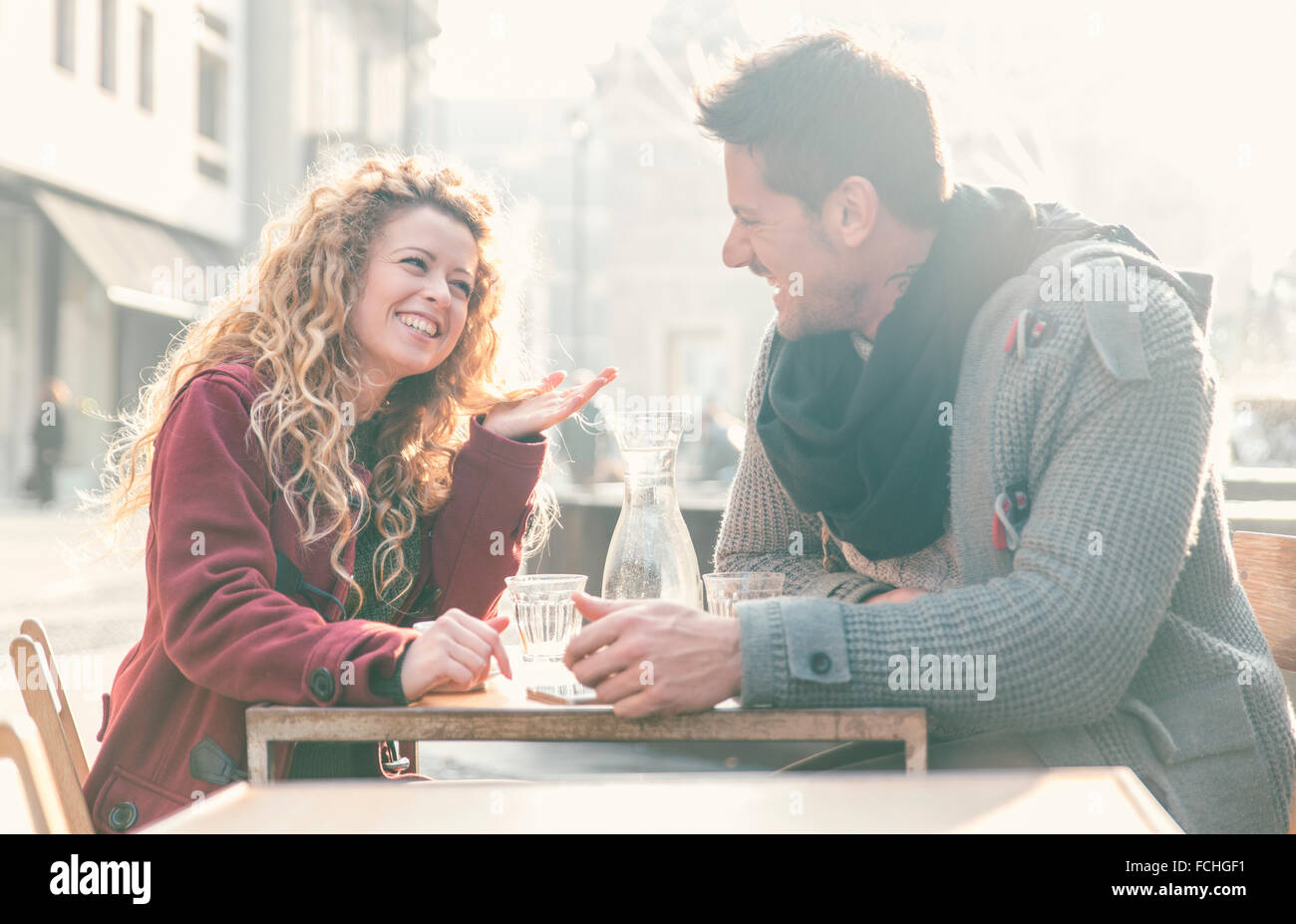 Italy Milan laughing couple sitting at sidewalk cafe having fun Stock ...