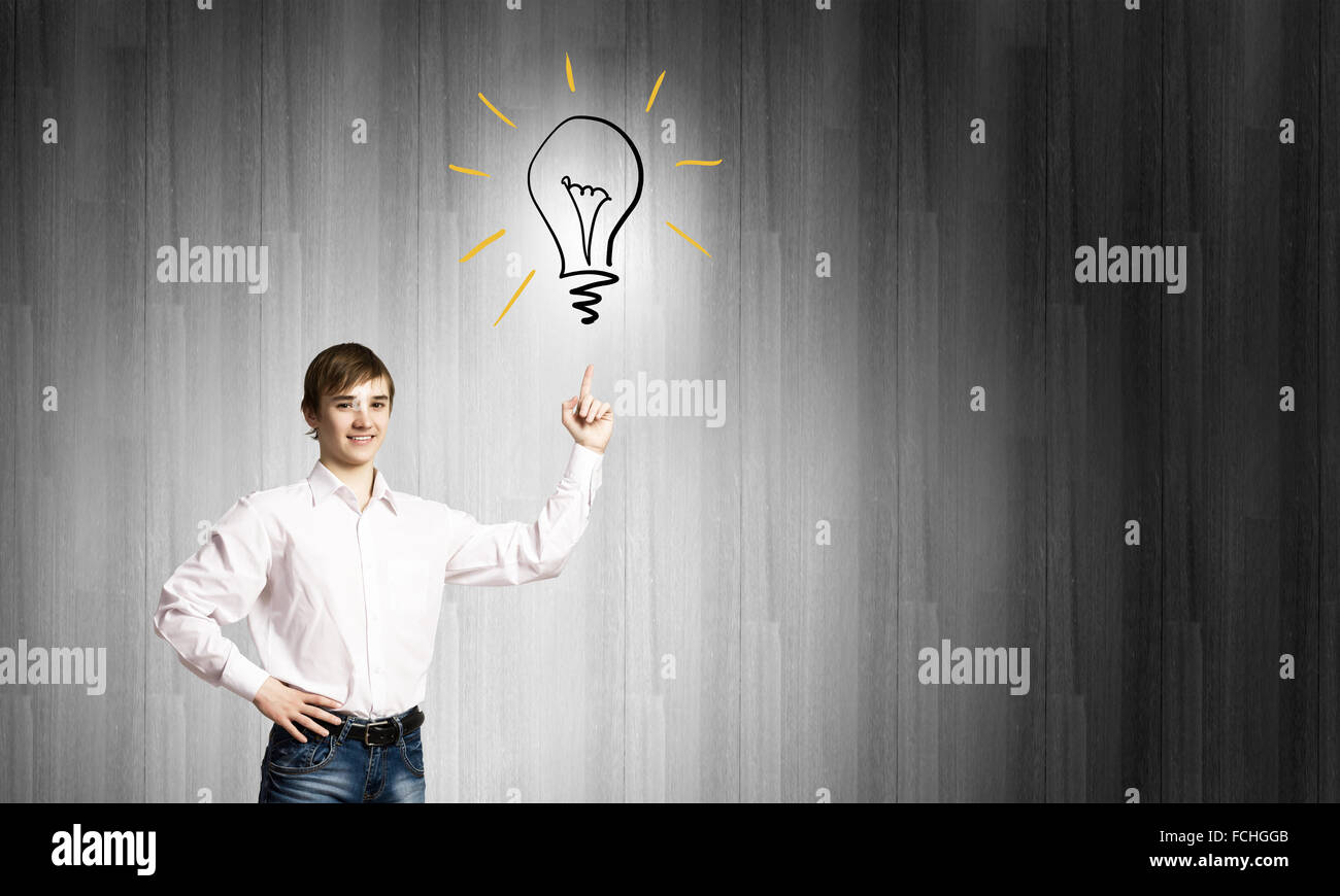 Schoolboy pointing at light bulb with finger. Idea concept Stock Photo ...