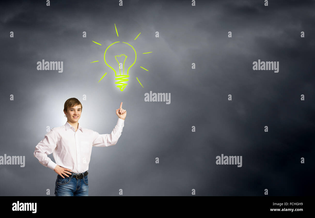 Schoolboy pointing at light bulb with finger. Idea concept Stock Photo ...