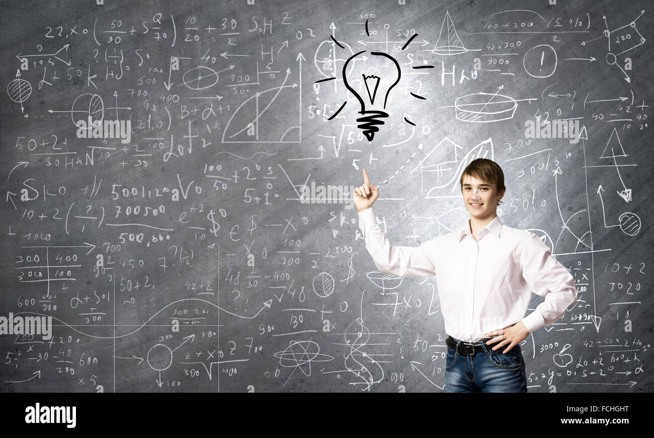 Schoolboy pointing at light bulb with finger. Idea concept Stock Photo ...