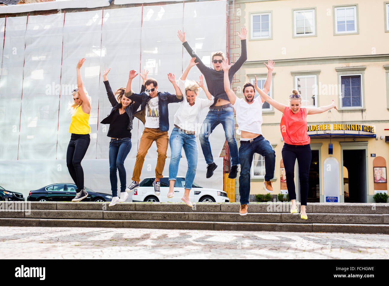 Enthusiastic friends jumping from stairs Stock Photo - Alamy