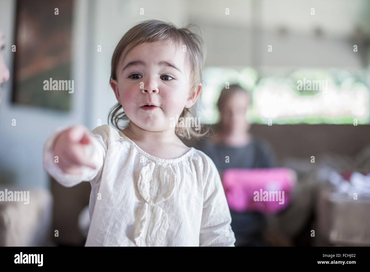 Baby girl at home pointing her finger Stock Photo - Alamy