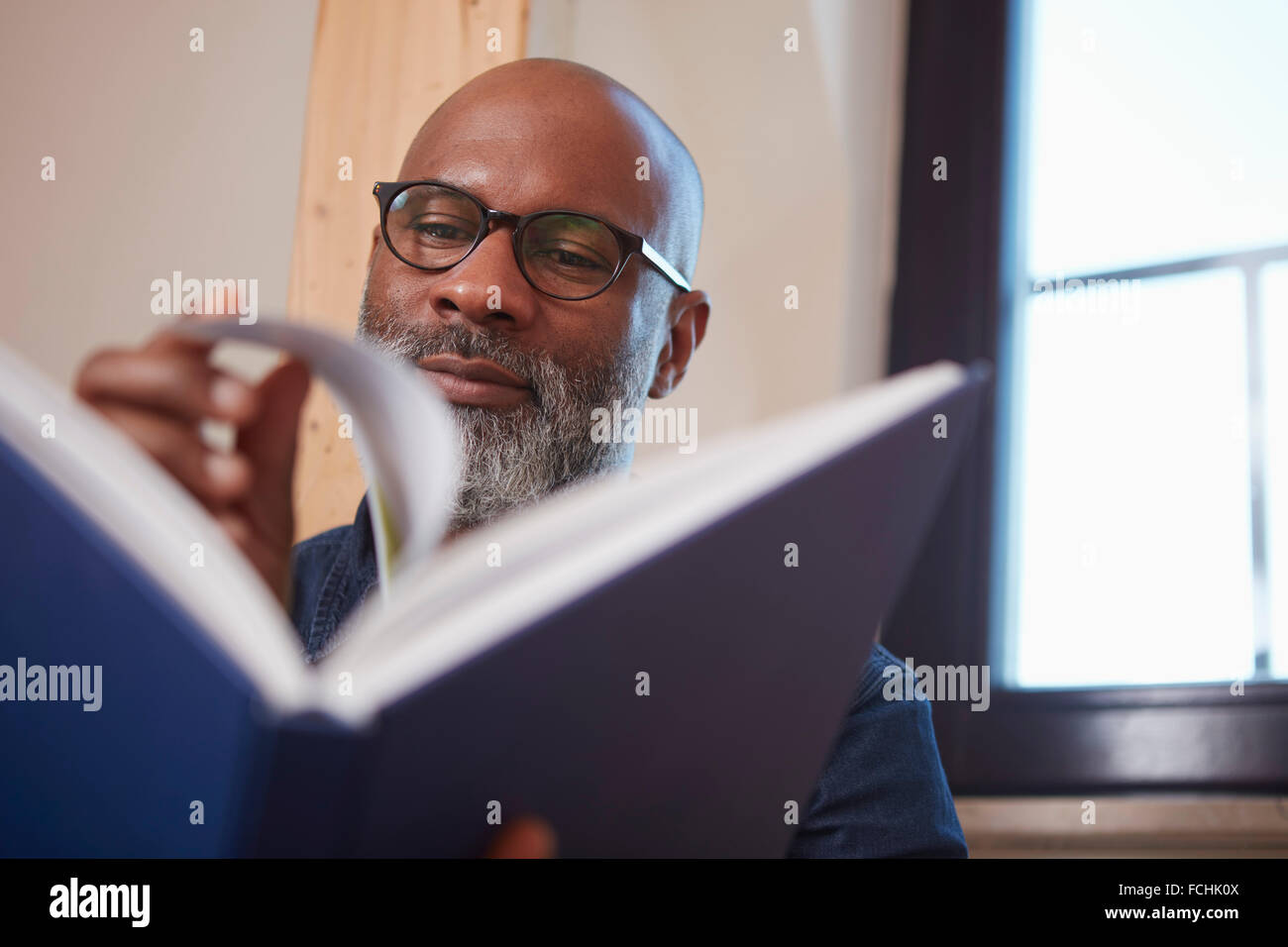 Portrait of man reading a book Stock Photo - Alamy
