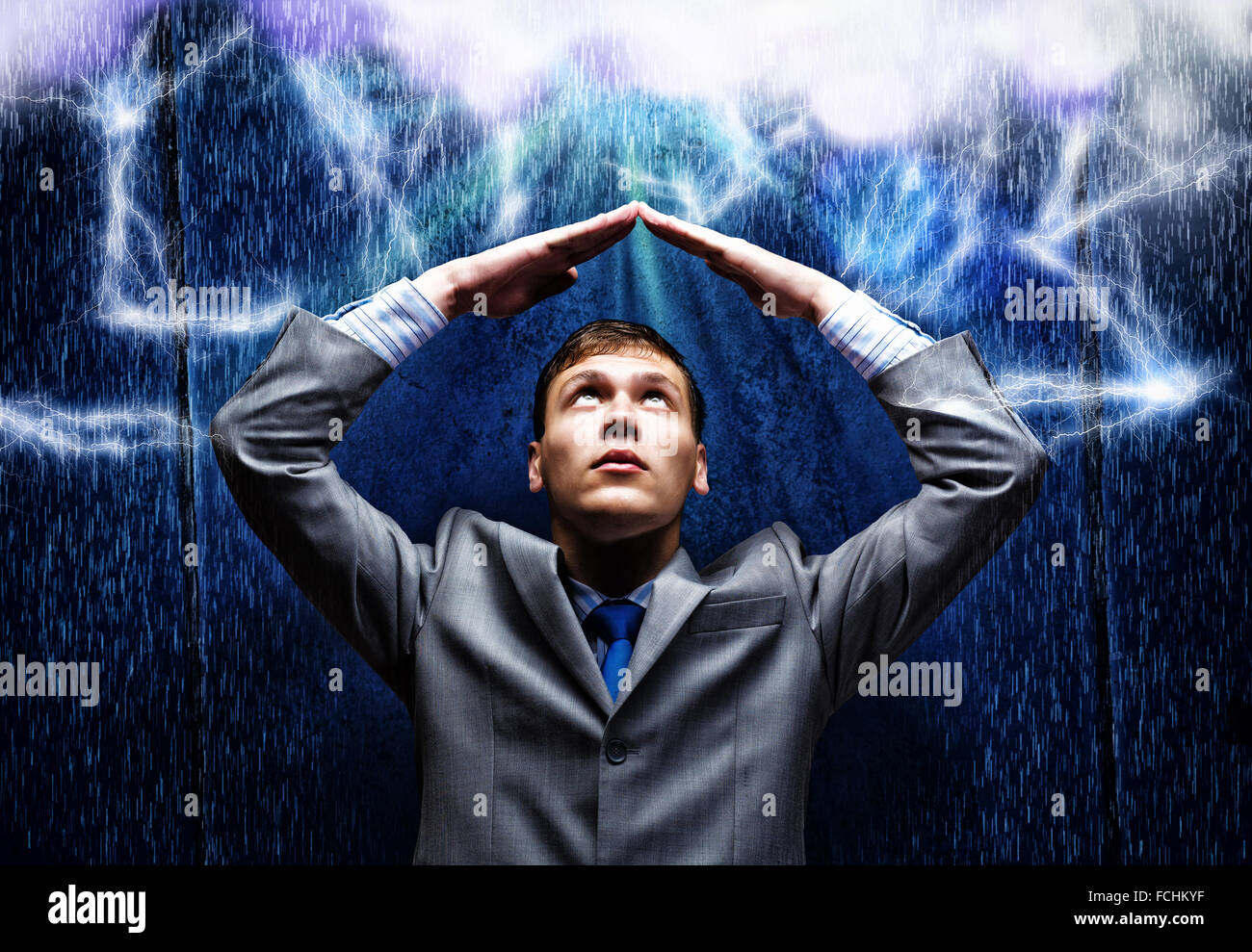 Young businessman under rain covering head with hands Stock Photo - Alamy