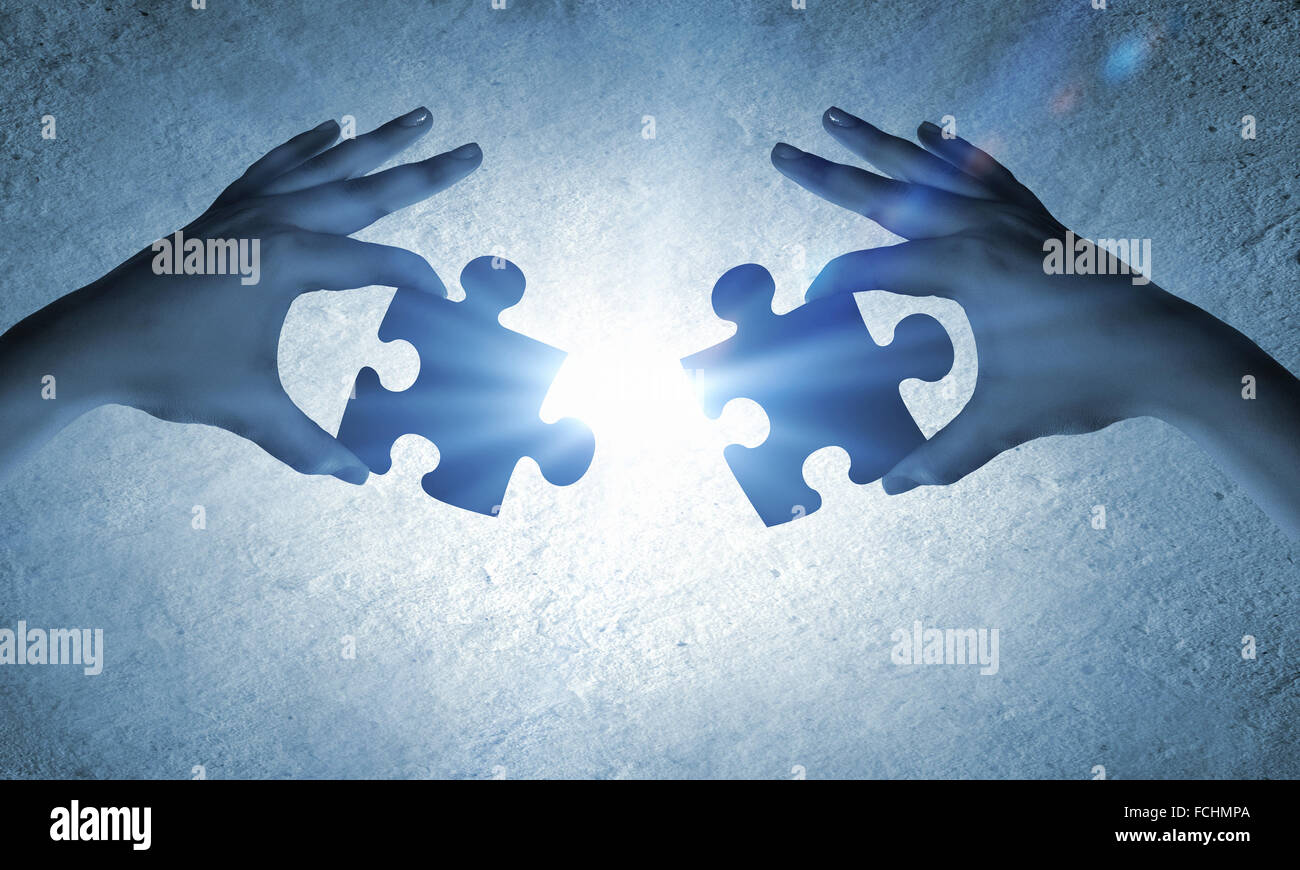 Close up image of hands connecting puzzle elements Stock Photo - Alamy
