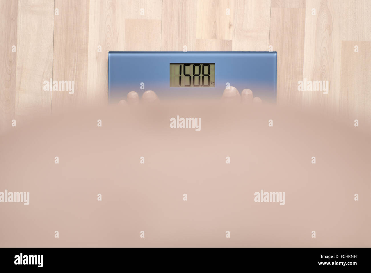 Heavy person weighing looking on the balance scale Stock Photo - Alamy