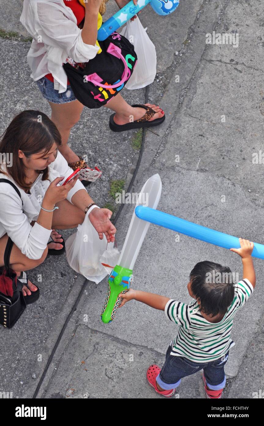 Itoman, Okinawa, Japan: bored mother at the traditional Haarii Boat ...