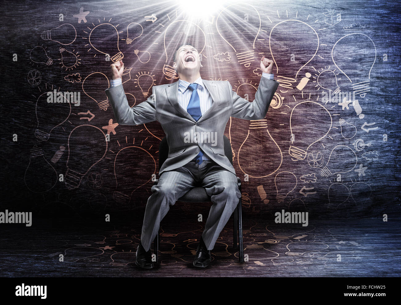 Young businessman sitting on chair and screaming joyfully Stock Photo ...