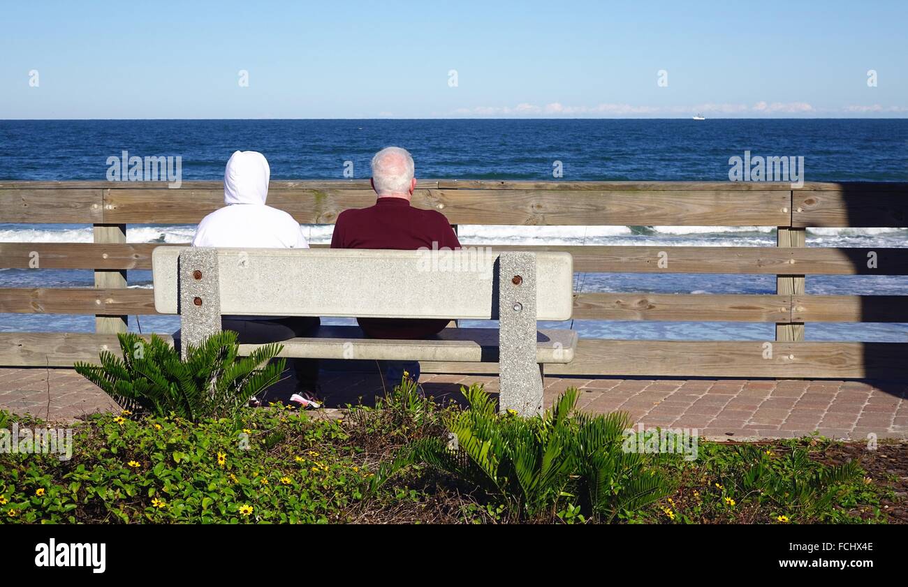 Couple sitting on a park bench watching the ocean at North Shore Park ...