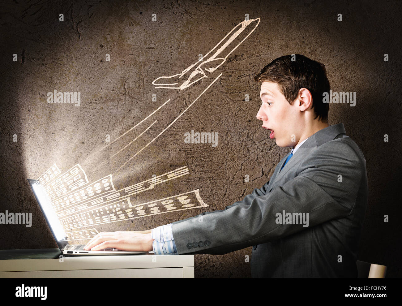 Young businessman looking shocked into laptop monitor Stock Photo - Alamy
